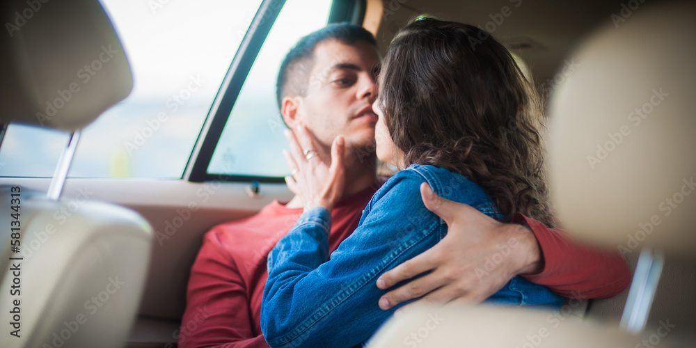 Passionate kiss in car. Young sexy couple in love, sitting in the back ...