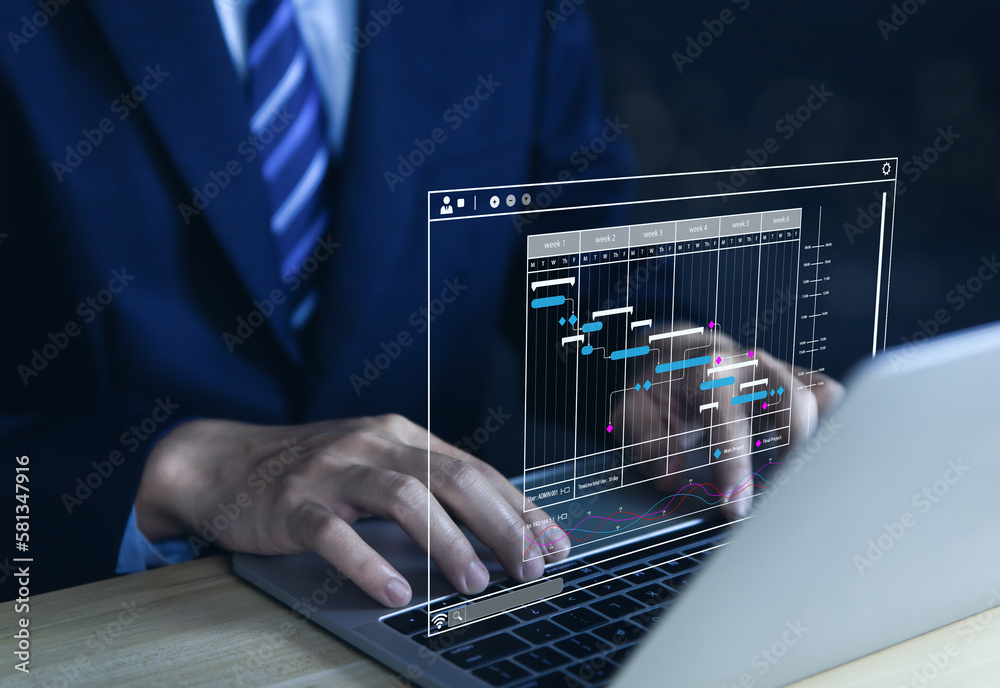 business manager managing business planning project schedules in the office. Gantt chart showing ...