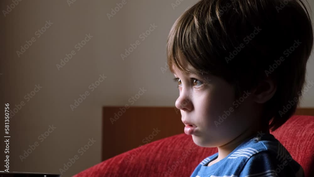 Vidéo Stock 6 year boy looking at screen. Child is watching TV ...