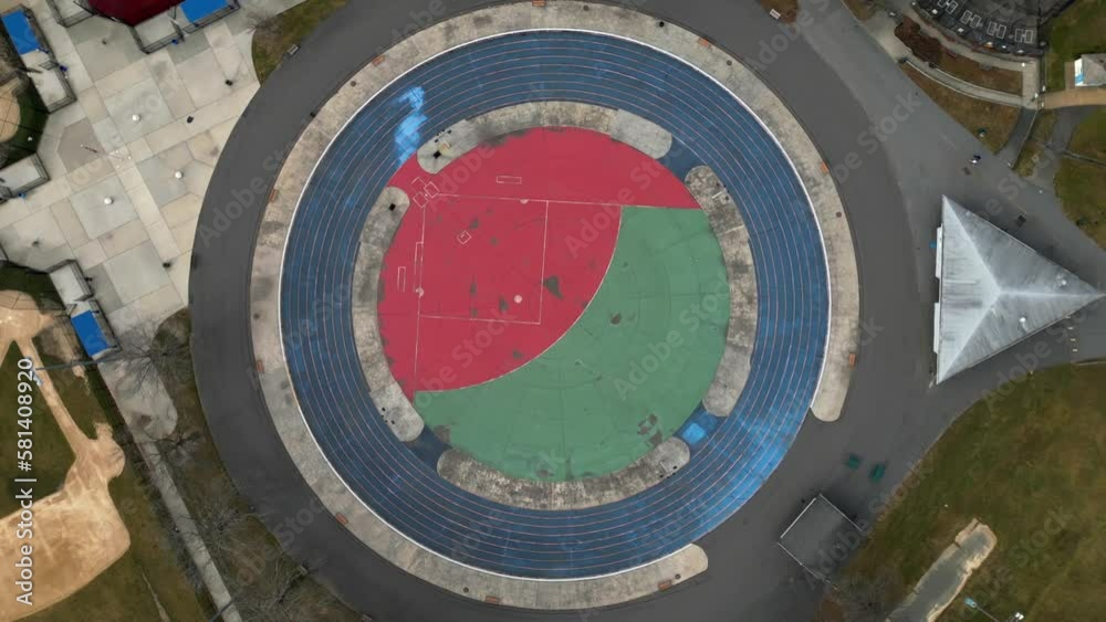 A top down view directly above a circular track and sports field in an ...