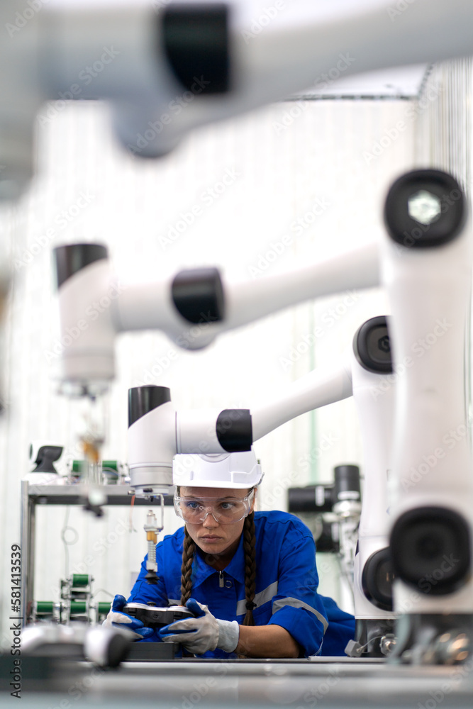 Robotic maintenance engineer working on robot arm connection and ...