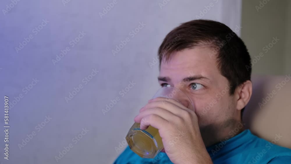 Close-up of the face of a plump man taking a few sips and drinking from ...