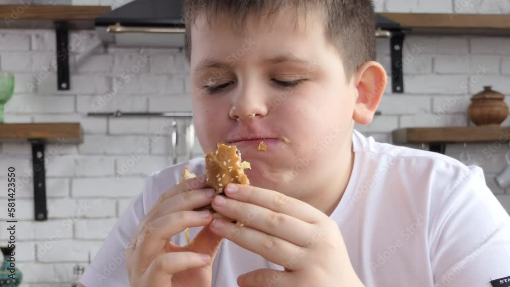 Little boy in fast food cafe eats burger. Portrait of hungry child Cute ...
