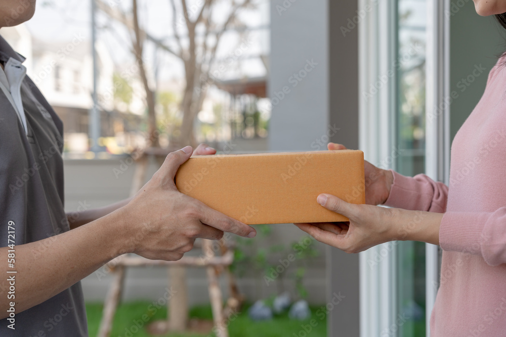 Happy smiling woman receives boxes parcel from courier in front house ...