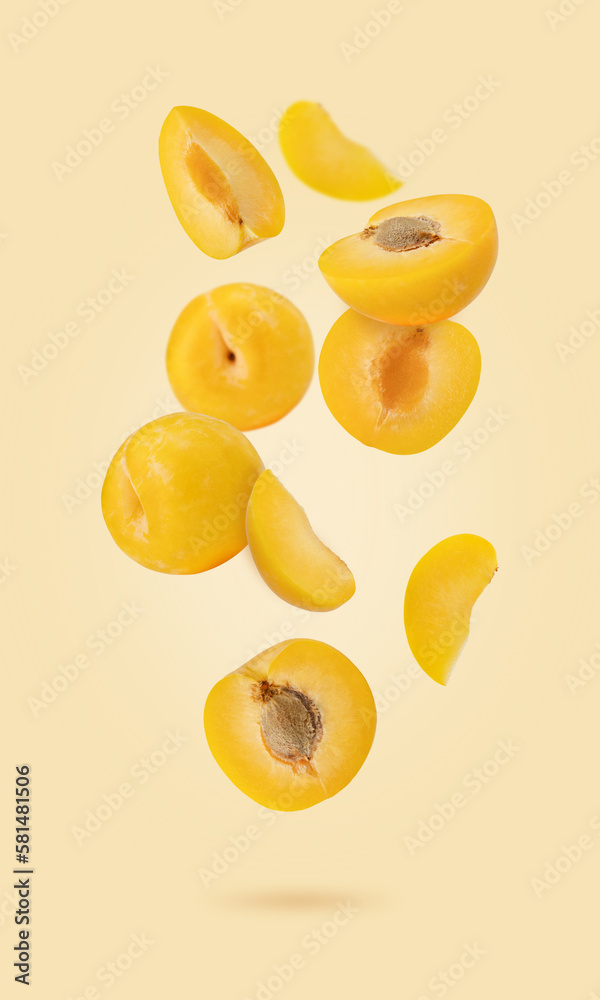 Fresh raw yellow plums falling in the air isolated on yellow ...