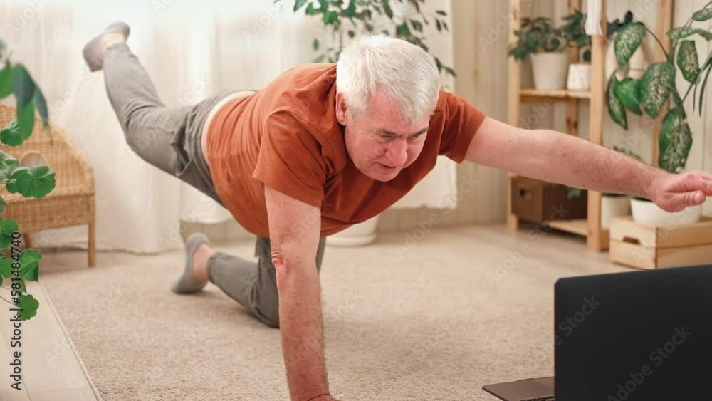 Happy mature senior man doing exercises of gymnastics at home online ...