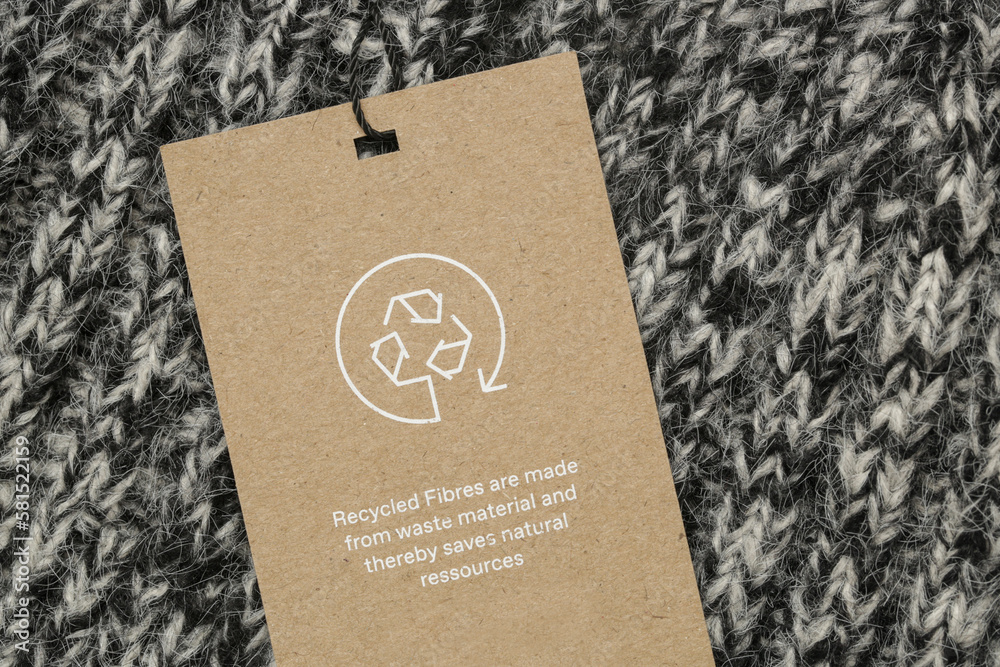 Foto de Close up of clothing tag with recycle icon. Recycling products ...