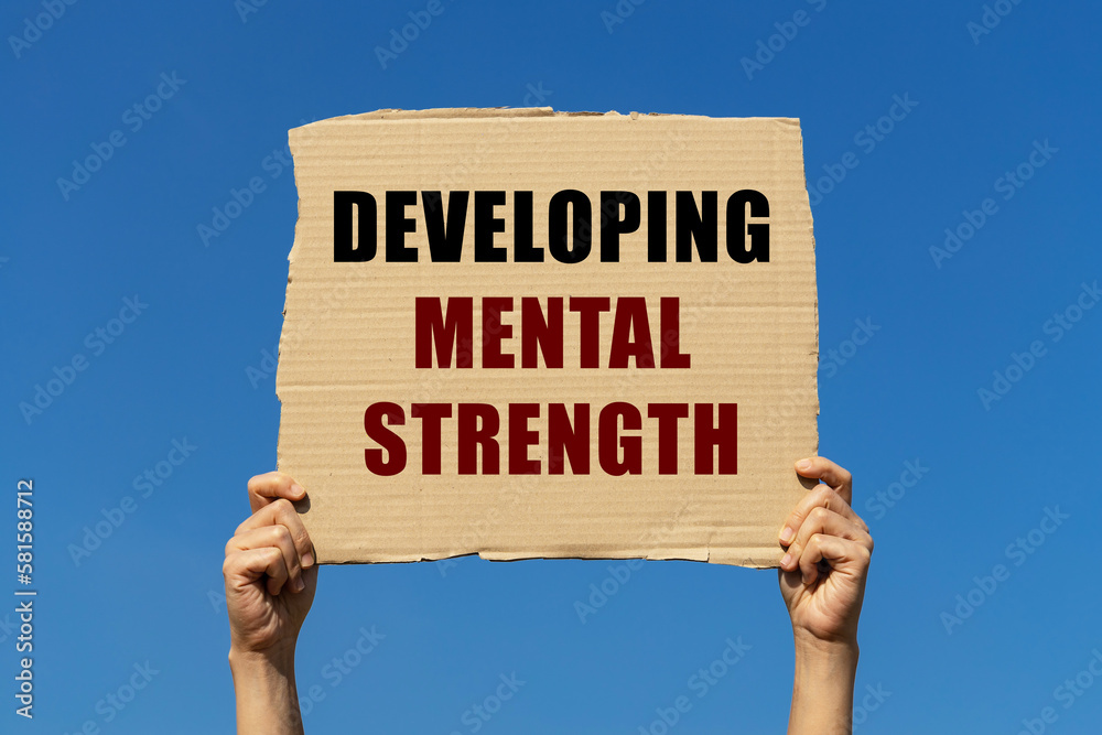 Developing mental strength text on box paper held by 2 hands with ...