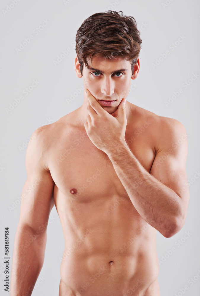 Smoldering manliness. A handsome young shirtless man posing in studio ...