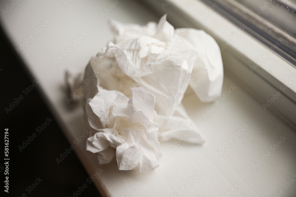 Tissue paper crumpled up by window showing public health sanitation ...