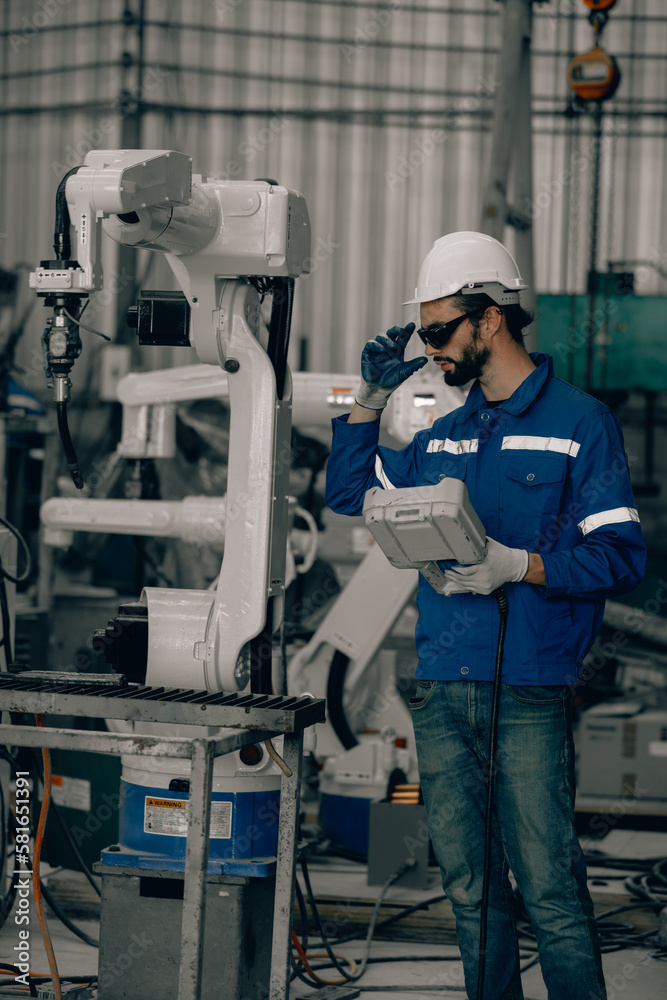 An male robotic welding operator is responsible for determining the ...