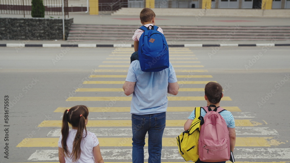 father leads child school holding his hand. dad takes children across ...