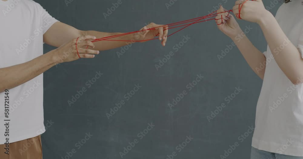 Man and woman moving hands tied with red rope expressing complicated ...