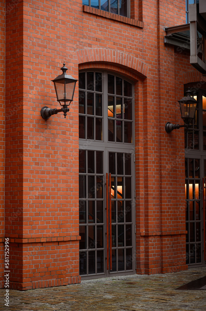 a large window in a brick building with a street lamp. Modern urban ...