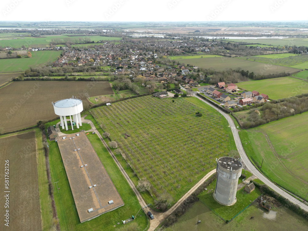 Drone view of a large concrete water tower on the left seen next to a ...
