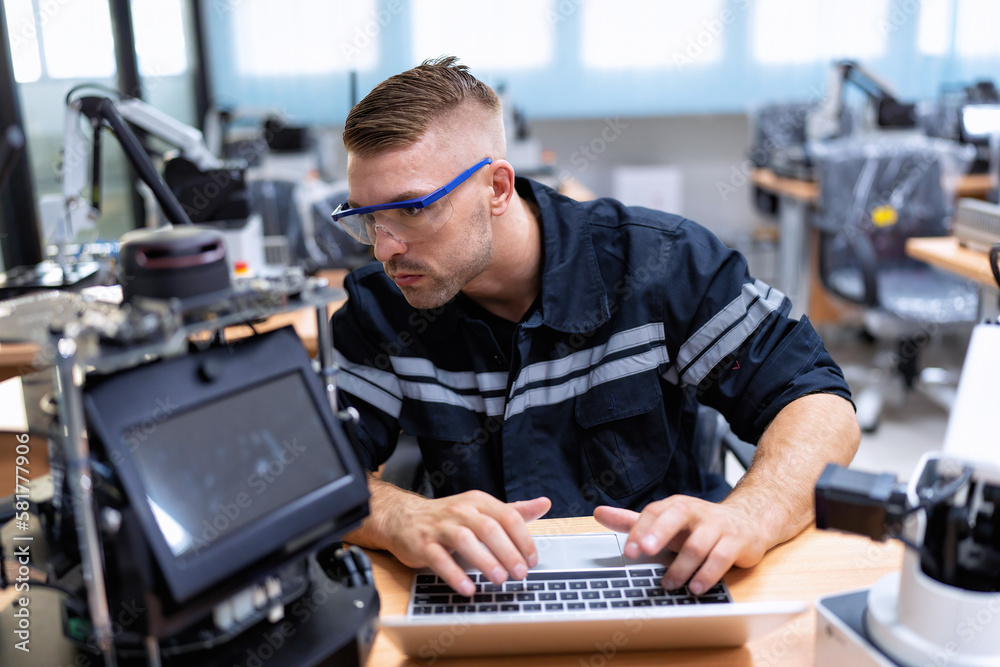 Engineer sitting in robot fab. room use laptop quality check and detail ...