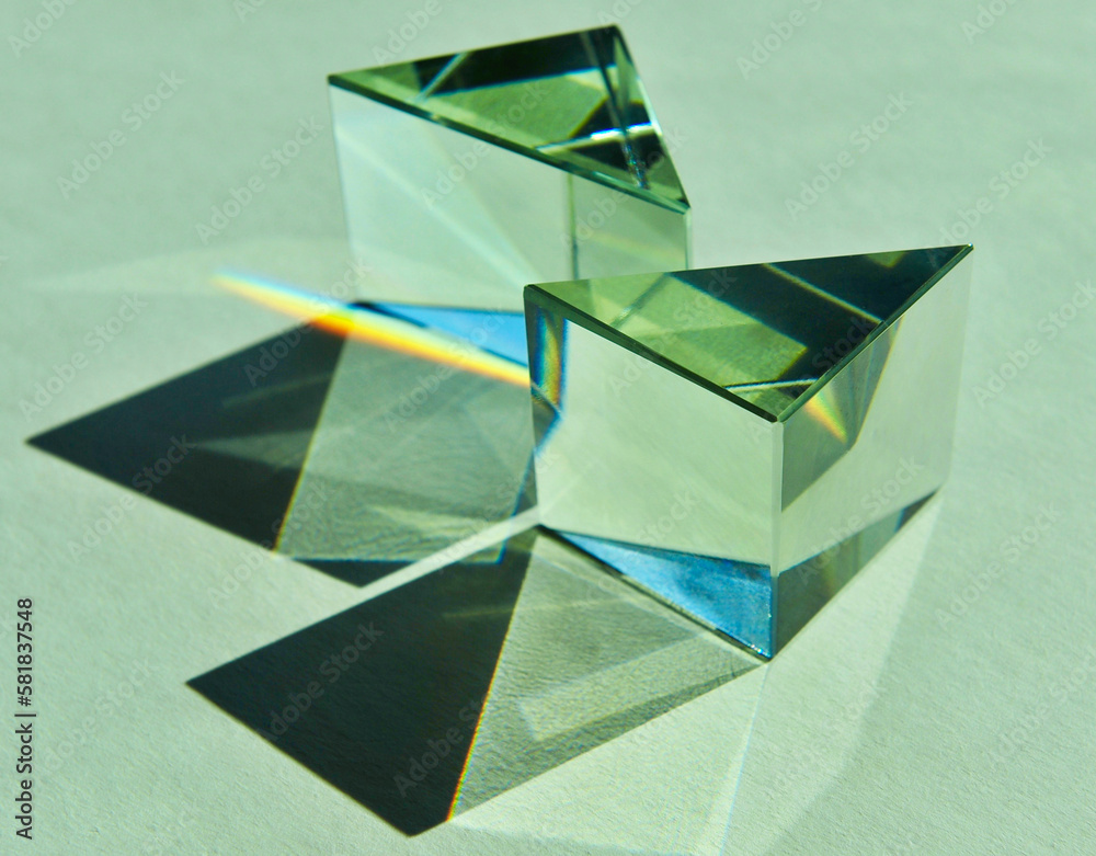 Glass prisms with reflective mirror surface refract ray of sunlight ...