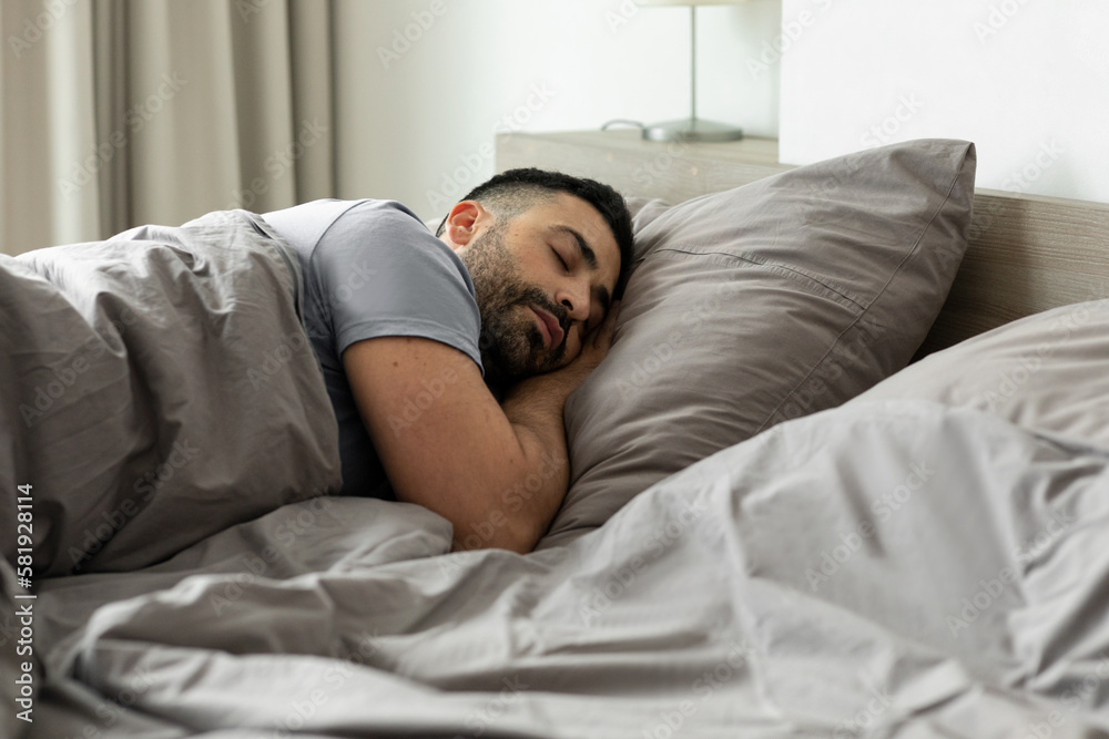 Calm middle aged man sleeping in comfortable bed on side, lying on soft ...