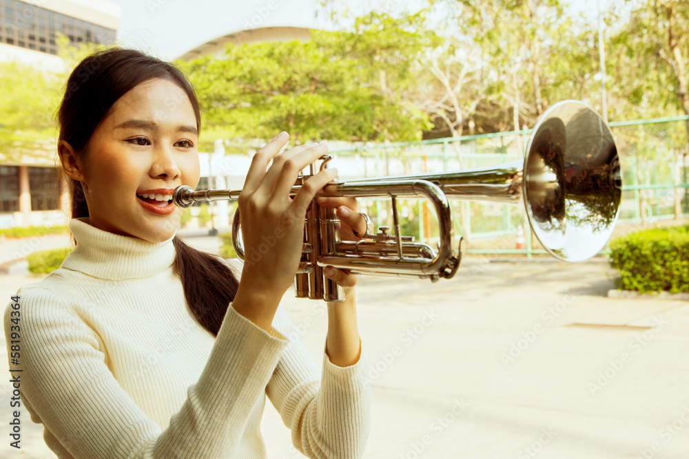 Beautiful asian teacher using sound power standing blowing instrument ...