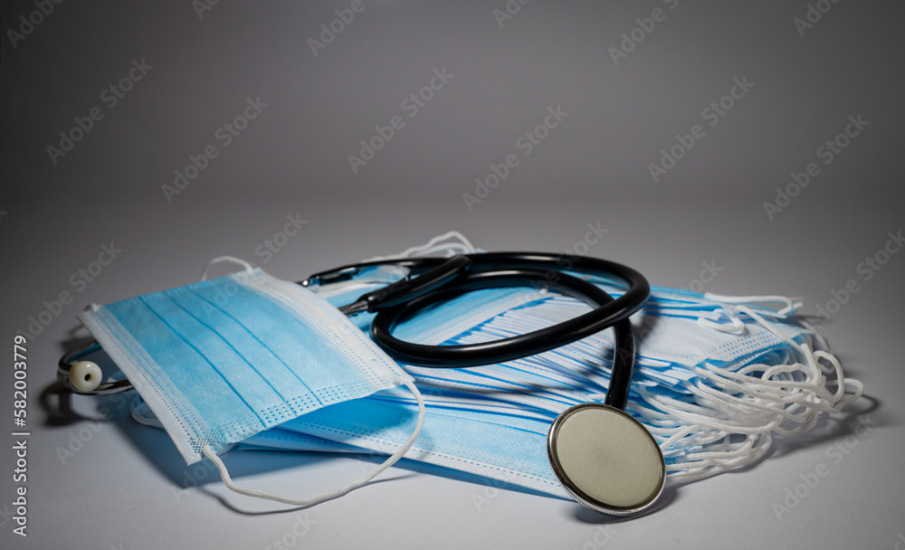 Blue surgical masks with rubber ears straps stacked in layers with ...