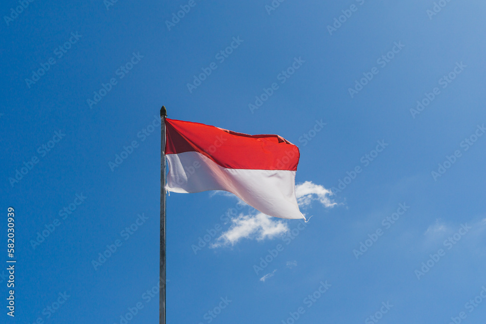 indonesia natonal flag "merah putih" fluttering with blue sky as a ...