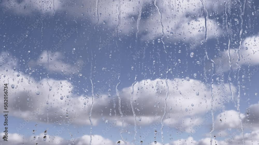 Rain Drops Flow Down Glass Against a Background of Moving Clouds and ...