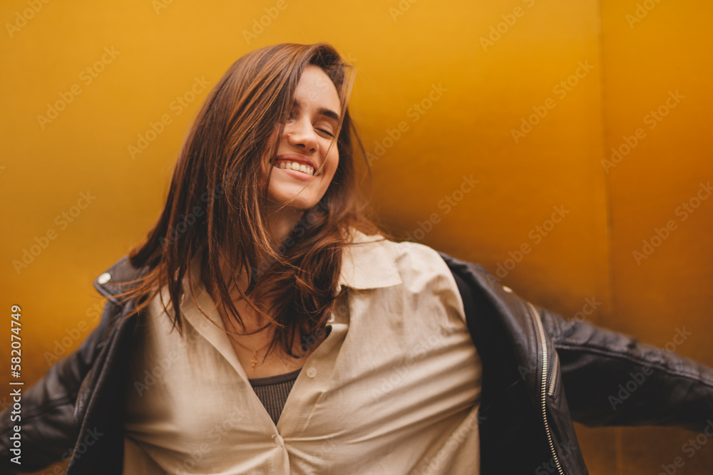 Simpering young brunette woman with a coy smile as she flirts over a ...