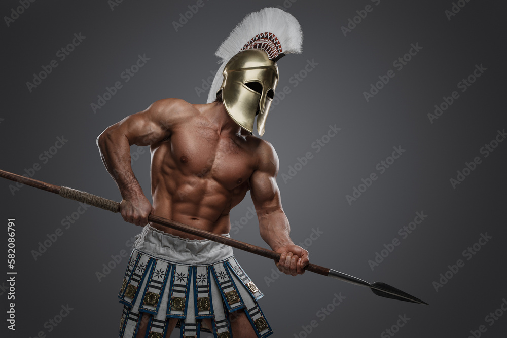 Shot of greek athlete with perfect body and spear dressed in plumed ...