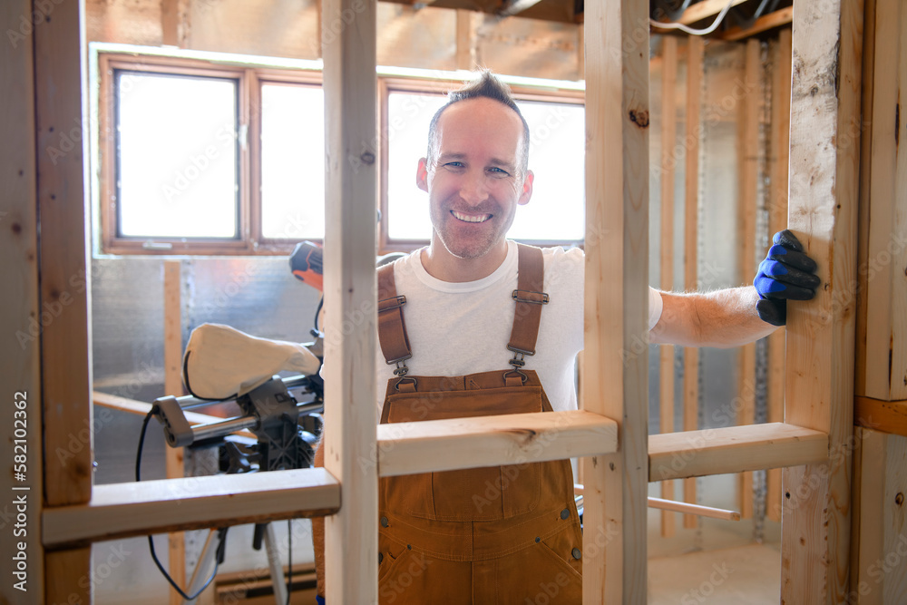 Construction Worker Using Power Tool in Unfinished Basement of New Home ...