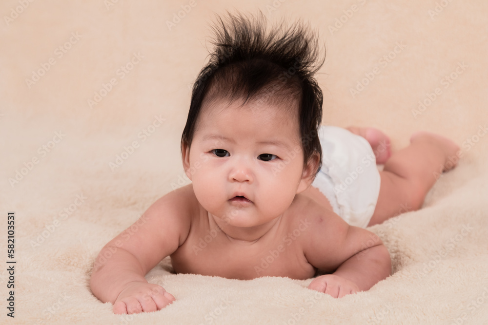 Asian newborn baby 3 month lying prone on beige soft bed. healthy ...