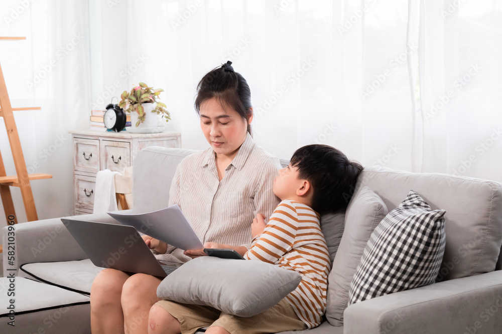 Asian little boy disturbed mother while single mom using laptop for ...