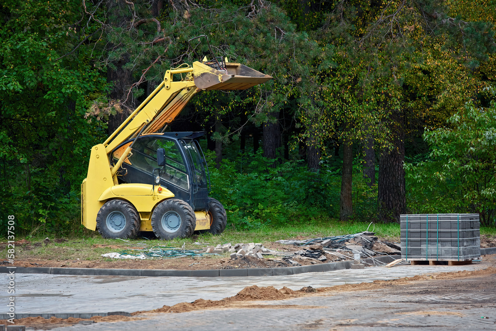 Sidewalk paving work, paving slabs pallet and small loader. Paving road ...
