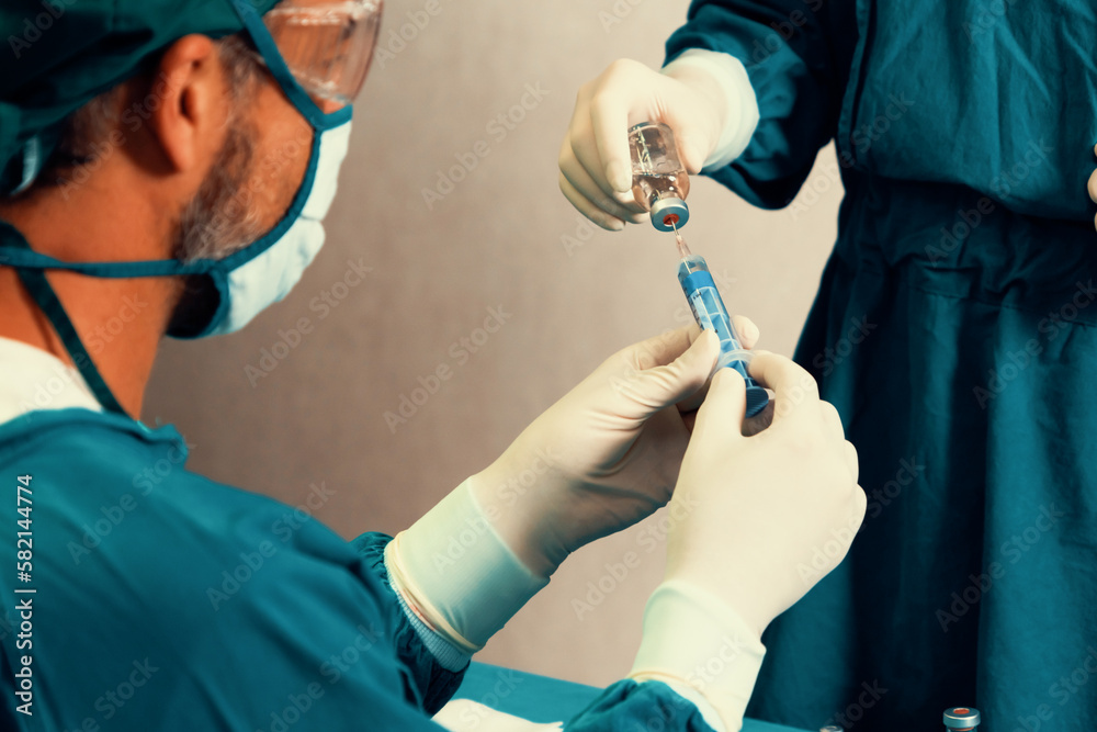 Foto de Surgeon fill syringe from medical vial for surgical procedure ...