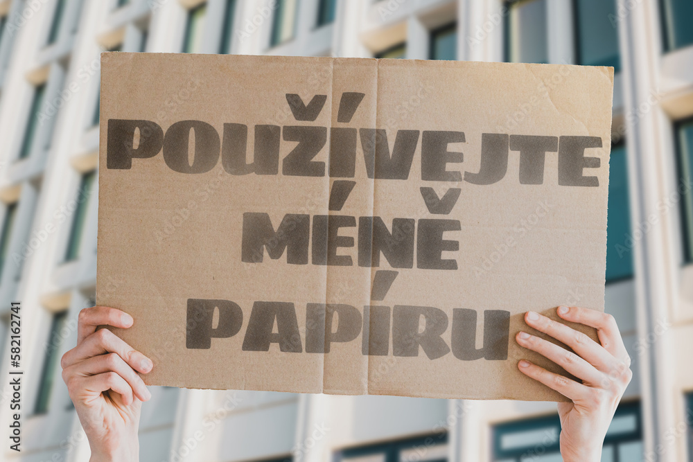 The phrase " Use less paper! " is on a banner in men's hands with ...