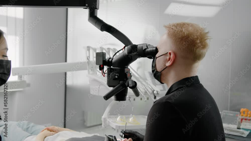 At the dental clinic a dentist examines a patient with a toothache ...