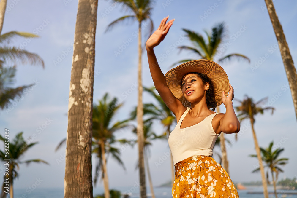 Young african female model posing in colorful clothes at tropical ...