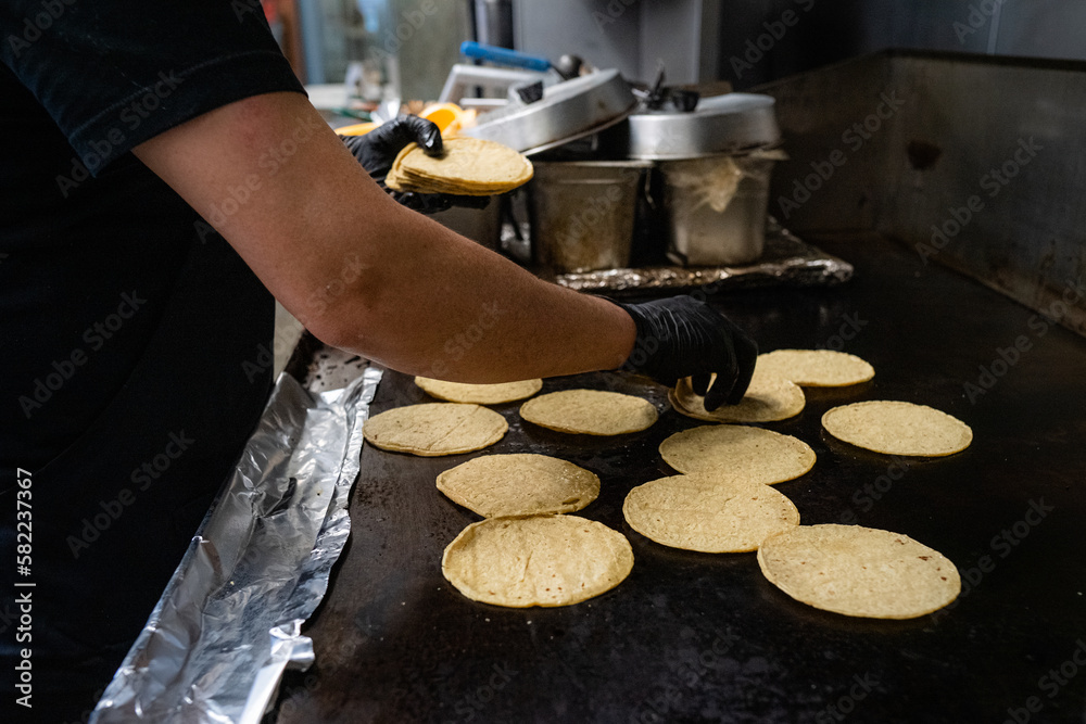 Chef at a mexican restaraunt grilling homemade tortillas on a hot grill ...