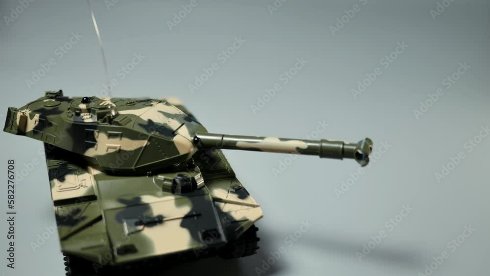 Close-up shot of an isolated radio-controlled toy tank that drives ...