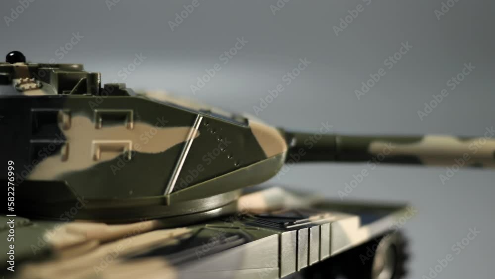 Close-up shot of an isolated radio-controlled toy tank that drives ...