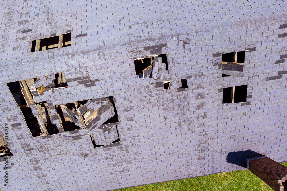 Broken roofing shingles house in a roof hole due to decay in aerial top ...