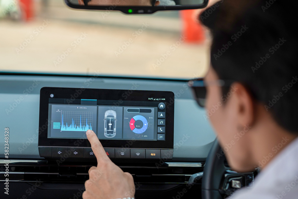An electric car driver is viewing the vehicle's electricity consumption ...