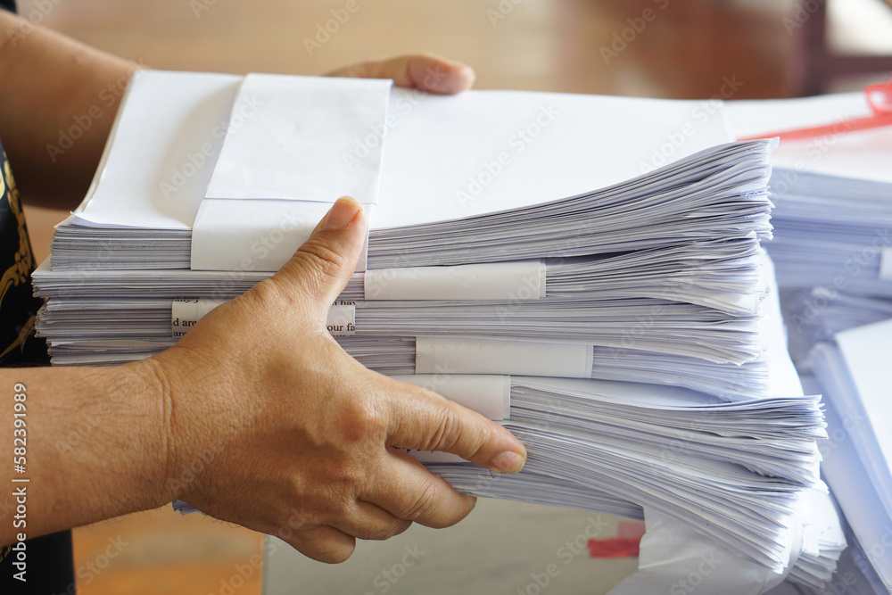 Closeup hands hold stack of used paper to recycle or combine to use ...