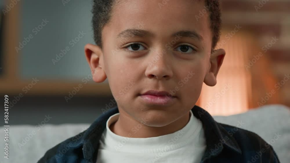 Portrait sad cute little African American boy looking down look at ...