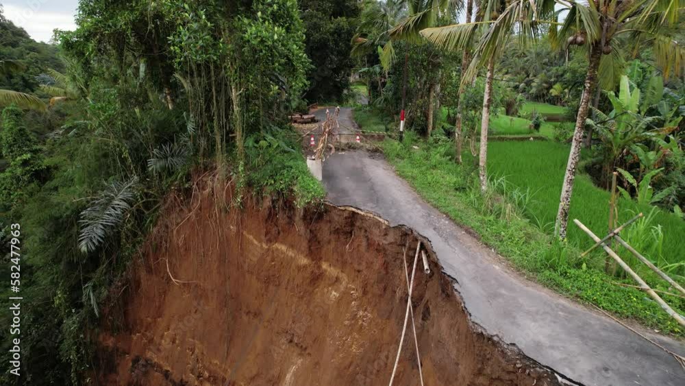 Close view of aftermath of landslide, local road destroyed and building ...