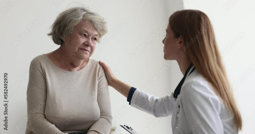 Positive empathetic doctor woman talking to elderly patient, smiling ...