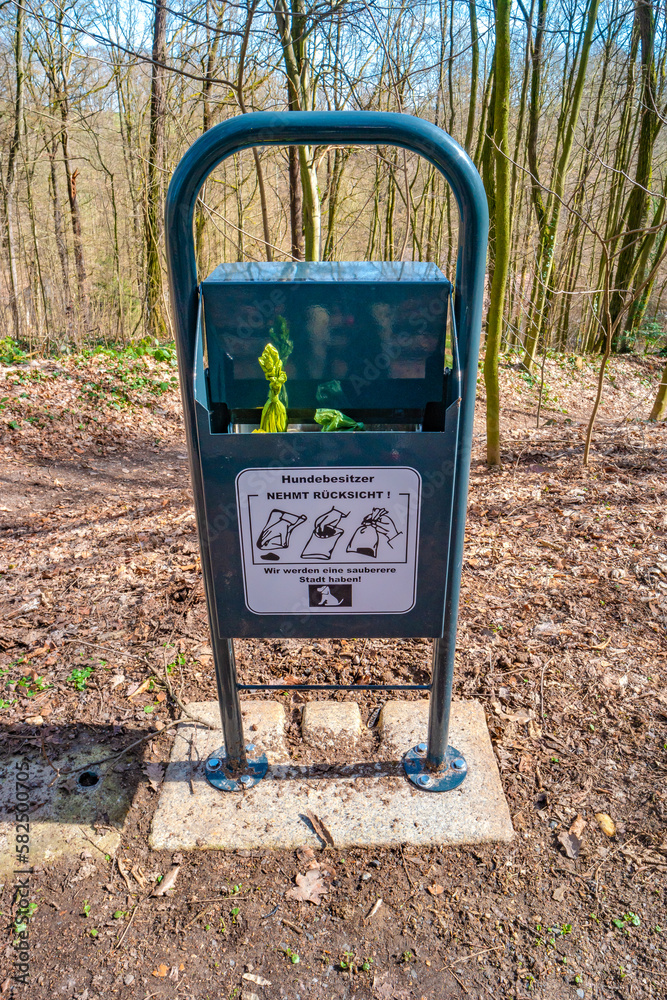 Foto de Trail trash bin in the city park with a sign of dog and note ...