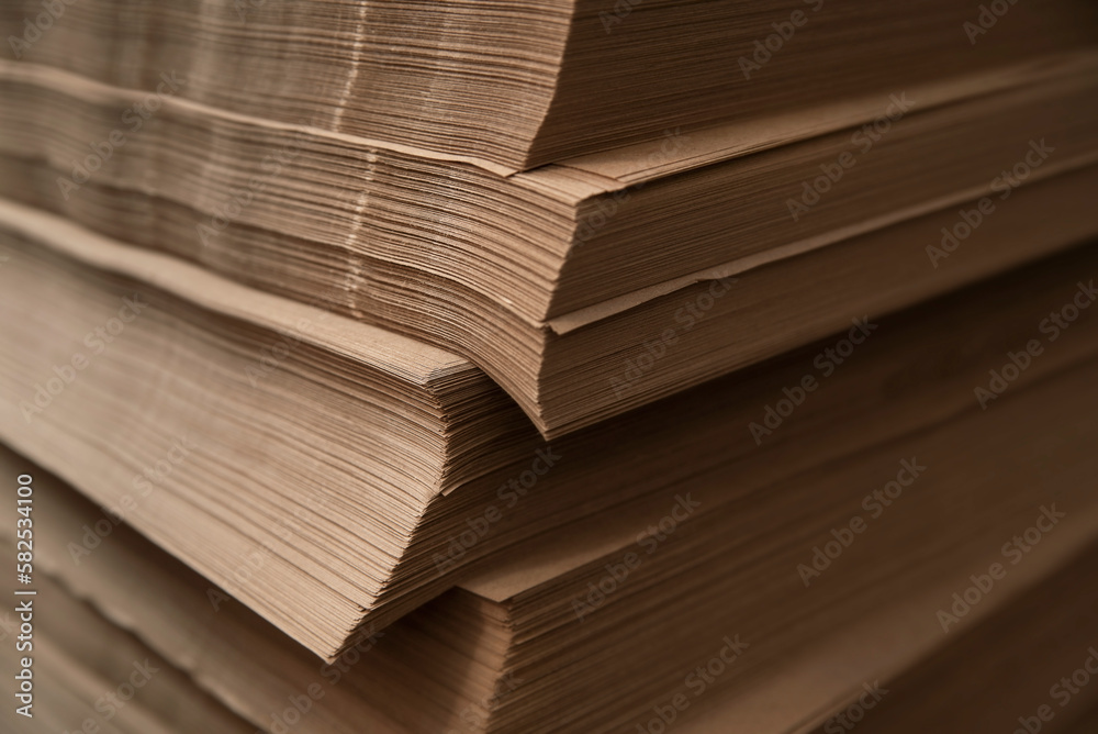 In the warehouse of packaging products, sheets of kraft paper lie in ...
