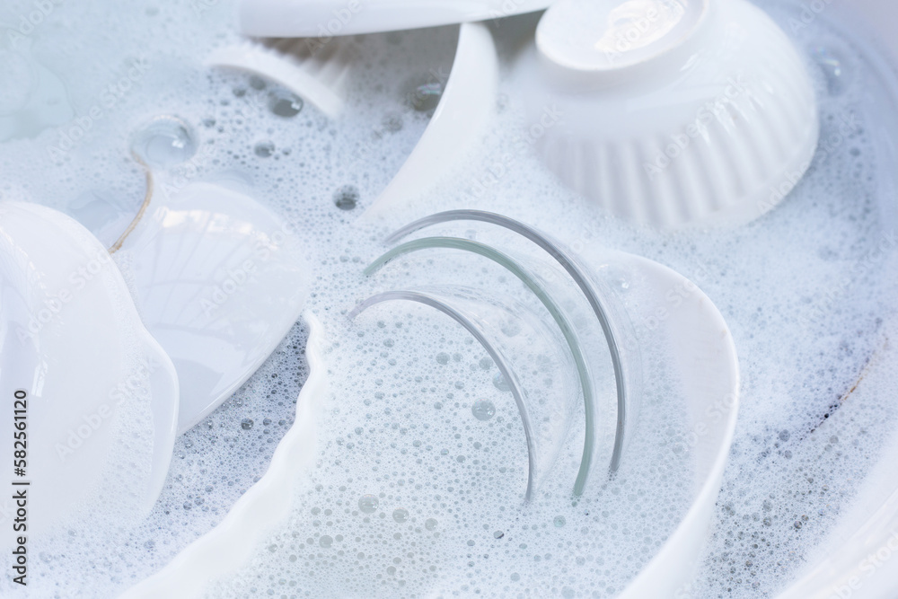 Dishes and bowls in water and bubbles of dishwashing liquid Stock Photo ...