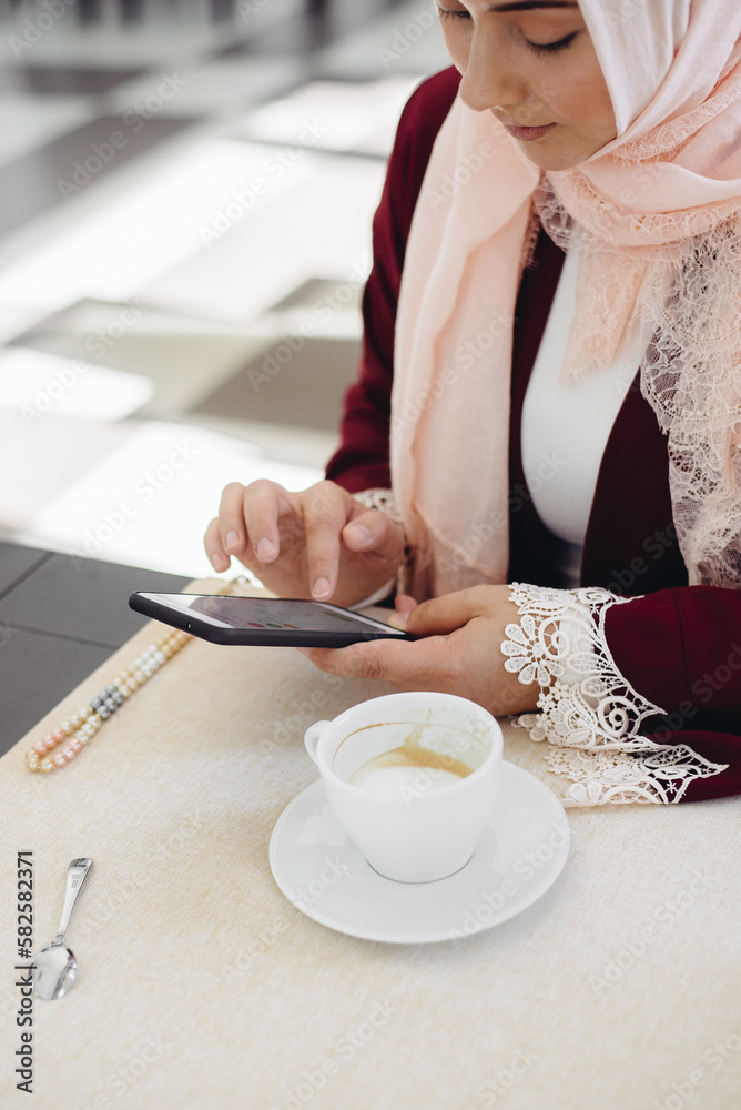 Muslim girl dials a number on a cell phone Stock Photo | Adobe Stock