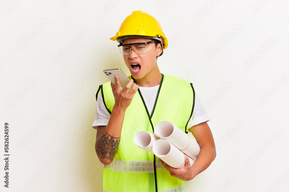 Young Asian man in yellow hard hat and yellow safety vest posing ...